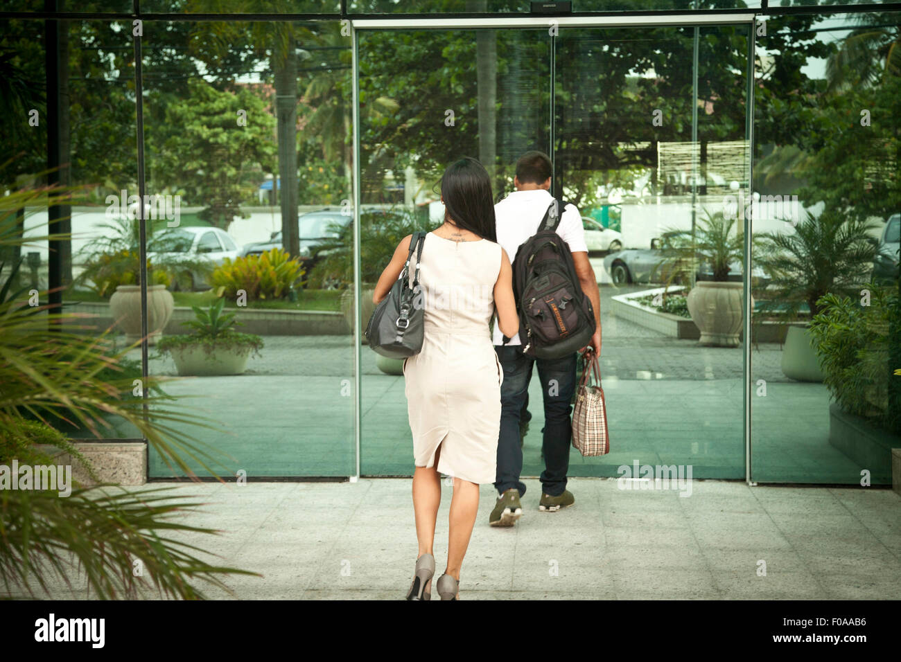 Mid adult couple, walking into building, rear view Stock Photo - Alamy