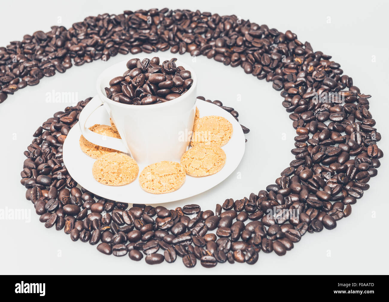 Cup full of coffee beans inside a coffee whirl Stock Photo - Alamy
