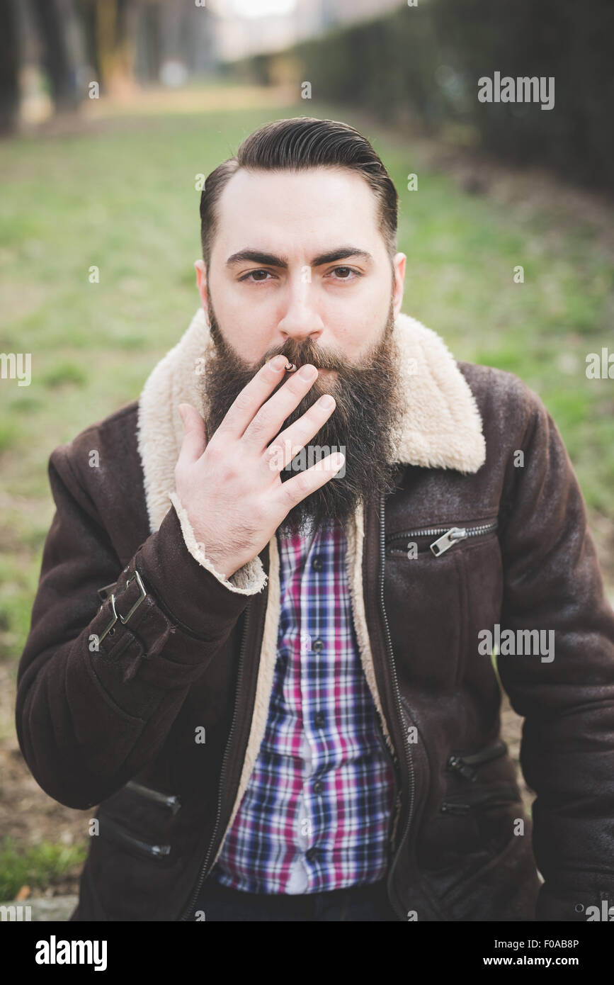 Young bearded man in park, Milan, Italy Stock Photo - Alamy