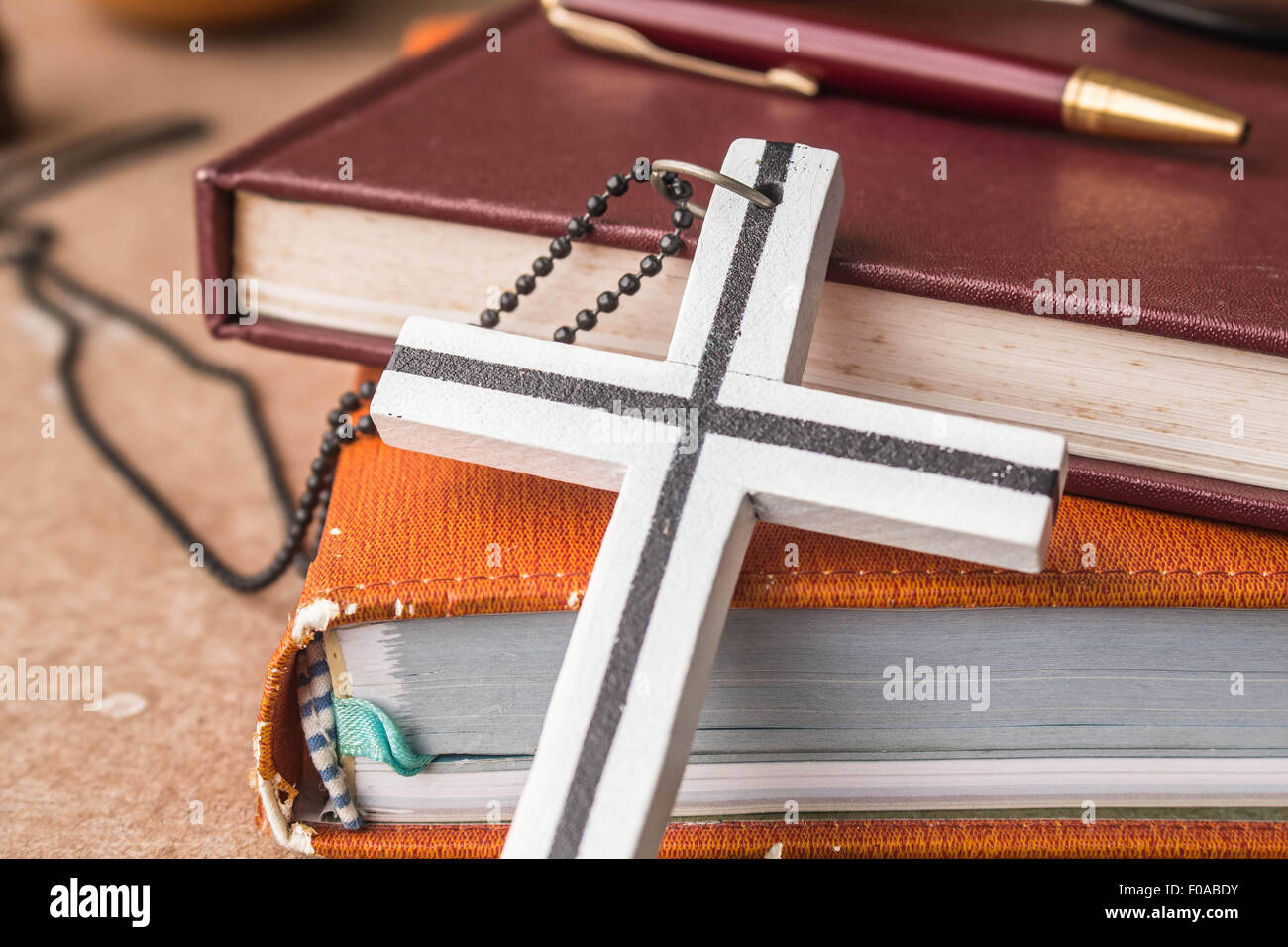 Cross placed leaning against an old book Stock Photo - Alamy
