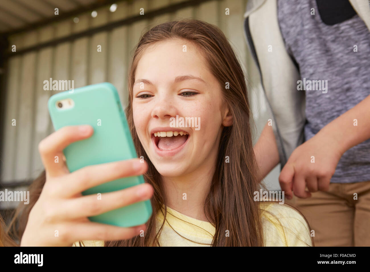 Girls laughing at smartphone in shelter Stock Photo - Alamy