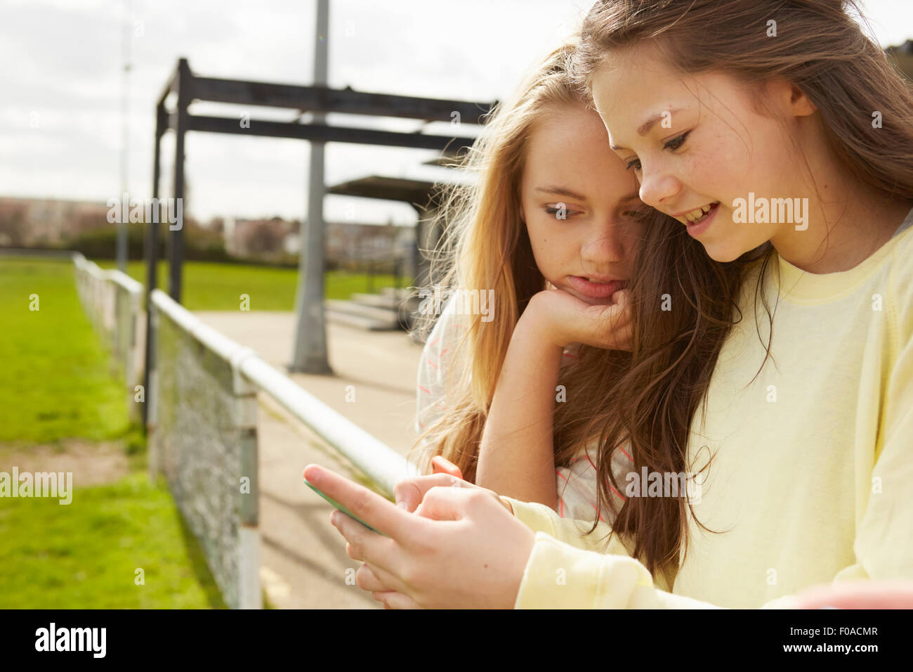 Two girls reading smartphone text message Stock Photo - Alamy