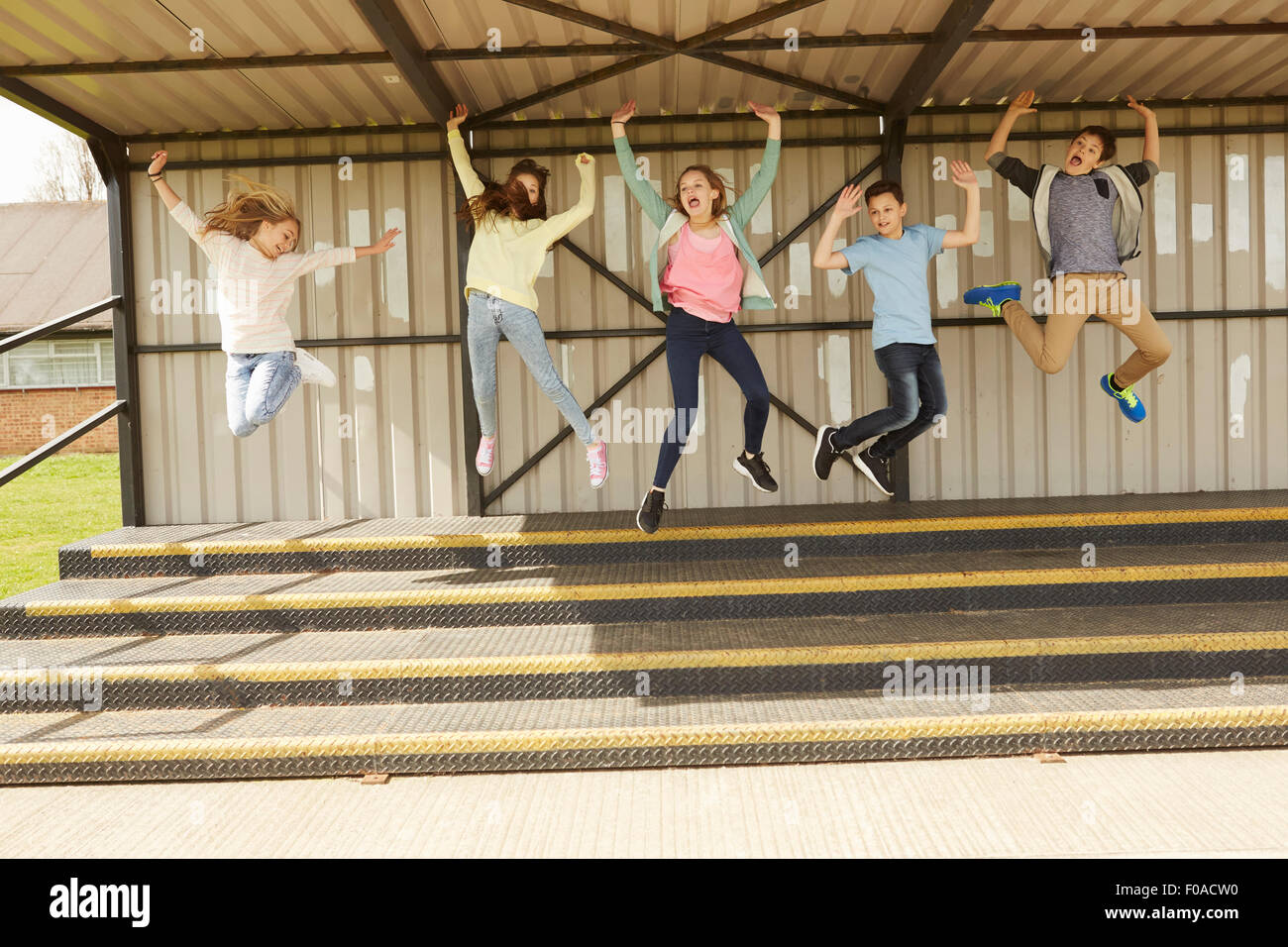 Five boys and girls jumping mid air in stadium stand Stock Photo - Alamy