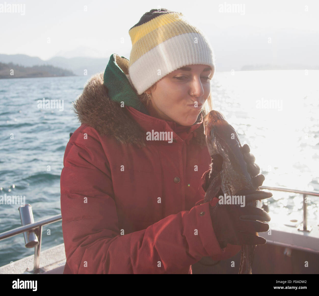 Young woman holding fish on boat Stock Photo - Alamy