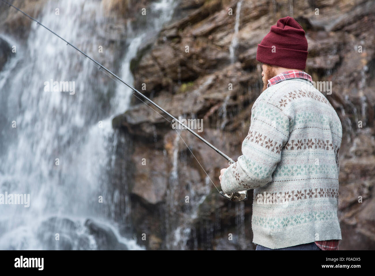 Man fishing by waterfall Stock Photo - Alamy