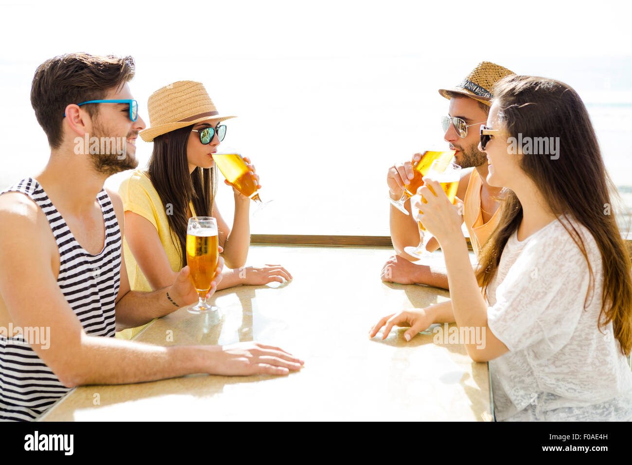 Friends having fun and drinking a cold beer at the beach bar Stock ...