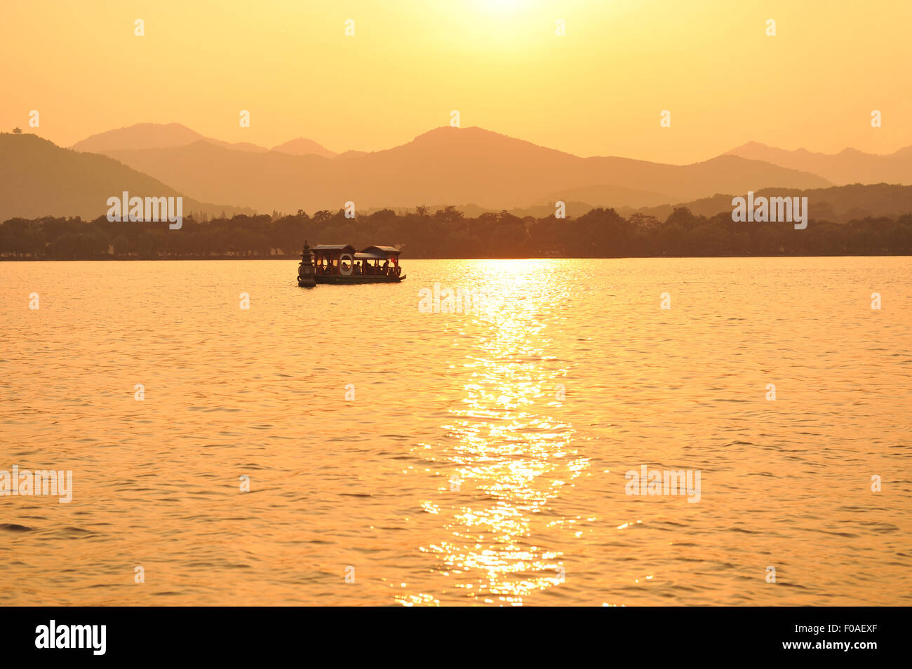 Boat on lake at sunset, Hangzhou, China Stock Photo - Alamy