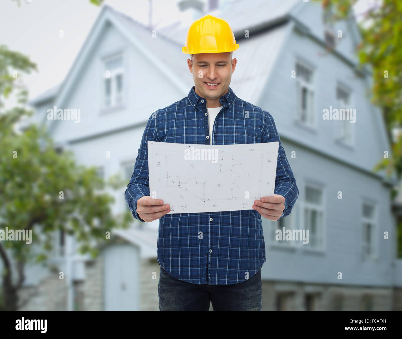 smiling builder with blueprint over house Stock Photo - Alamy