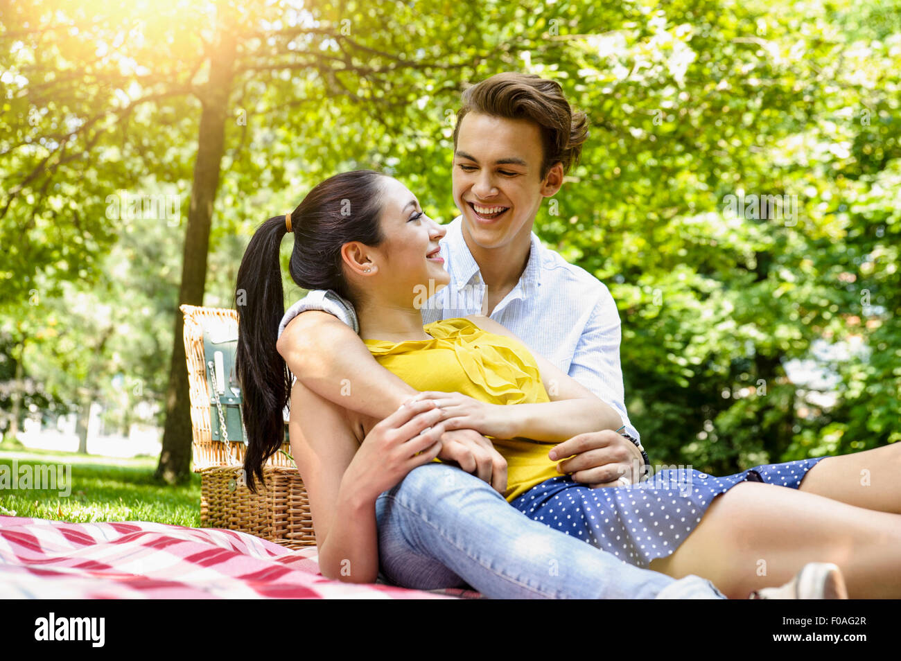 Young couple snuggling together on picnic blanket Stock Photo - Alamy