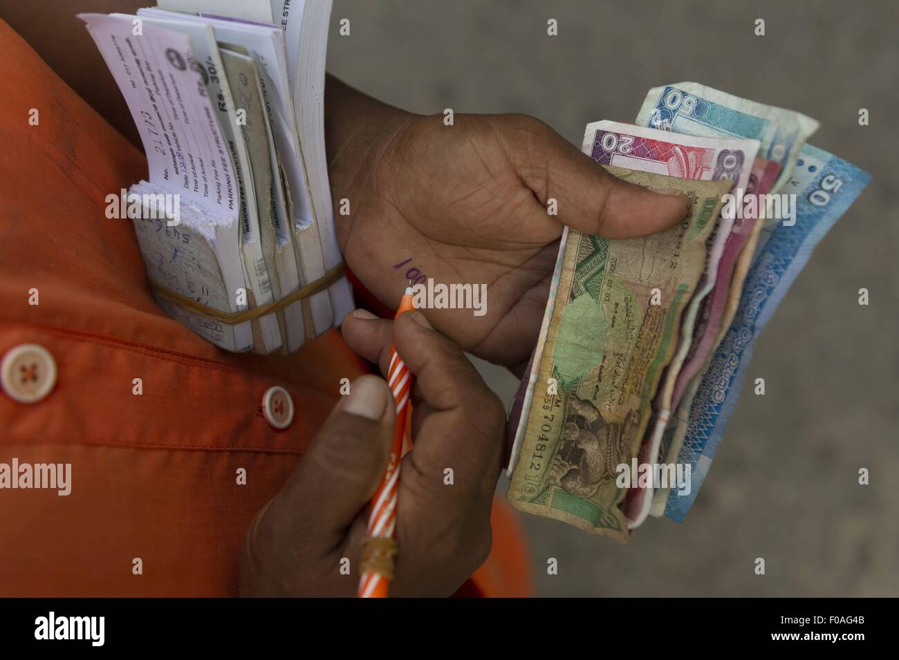 Man counting notes and writing figures on hand, Colombo, Sri Lanka ...