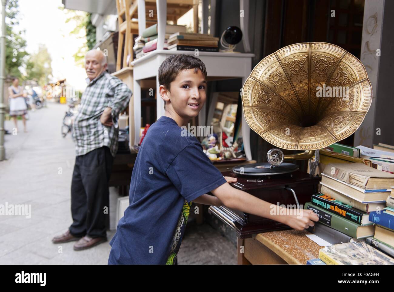 Boy standing at Turkish junk shop on street, Neukolln, Berlin, Germany ...