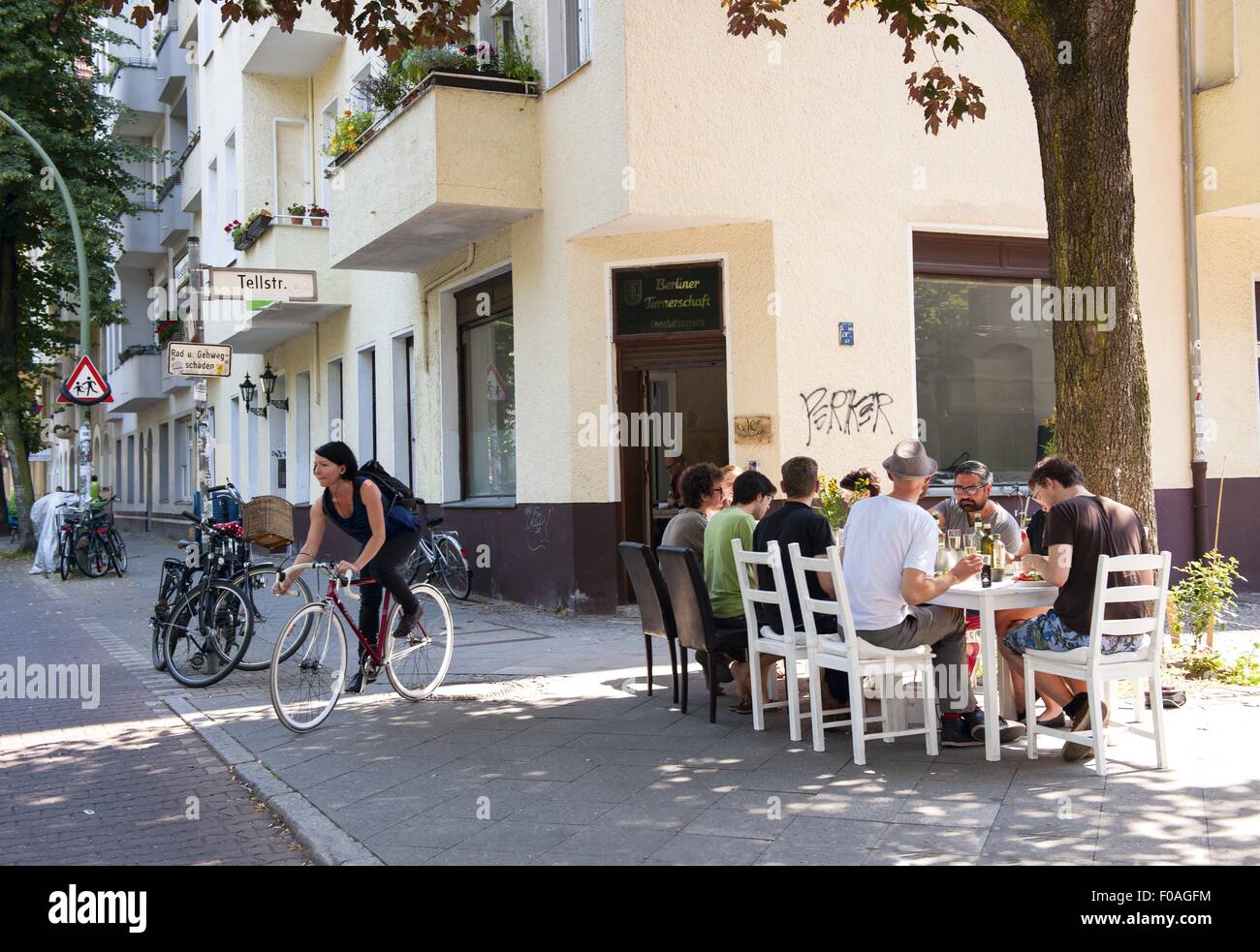 People sitting on street dinning table at Weserland, Neukolln, Berlin ...