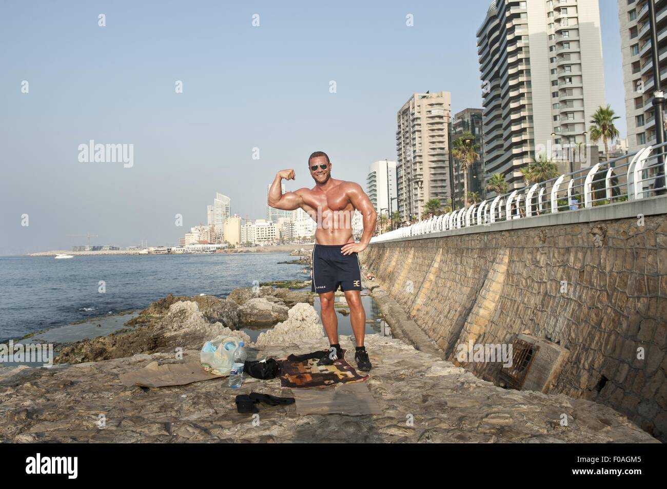 Man on shore showing his muscles in Beirut, Lebanon Stock Photo - Alamy