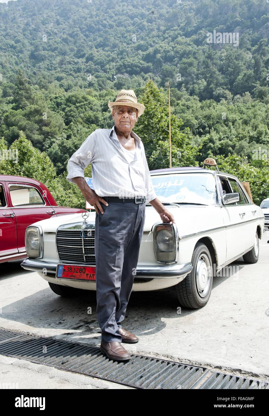 Taxi driver in front of old Mercedes line 8,8 in white at Beirut ...