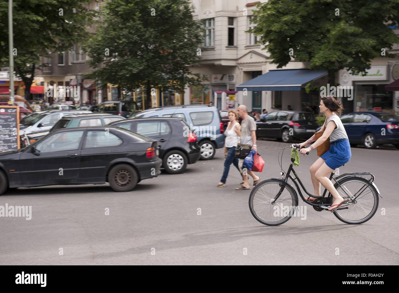 Woman riding bicycle on street in Maybachufer, Neukolln, Berlin ...
