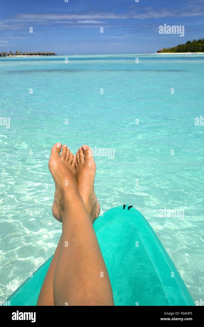 Close-up of legs in shallow water in Veliganduhuraa island, Maldives ...