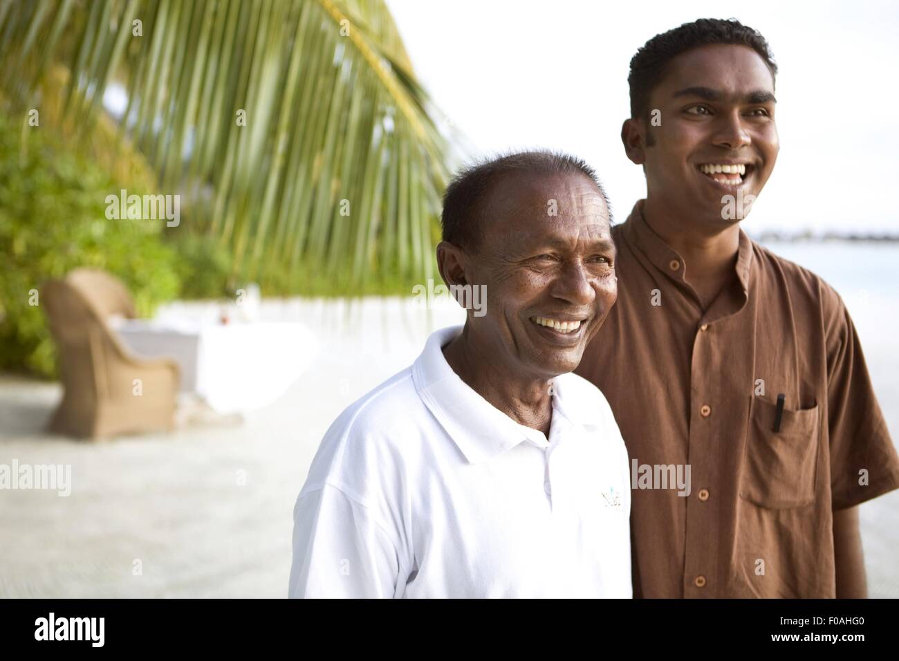 Two men smiling on beach of Veliganduhuraa, Maldives Stock Photo - Alamy