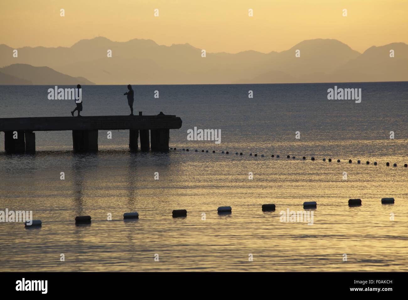 Locals on jetty at sunrise in Kargi bay, Datca, Resadiye Peninsula ...