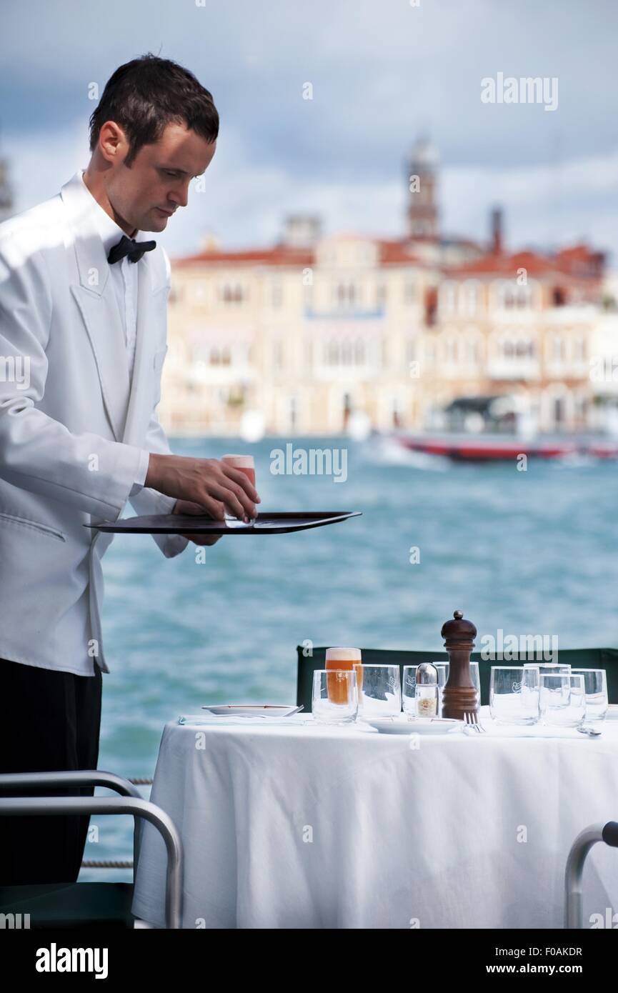 Waiter serving water in restaurant, Venice, Italy Stock Photo - Alamy