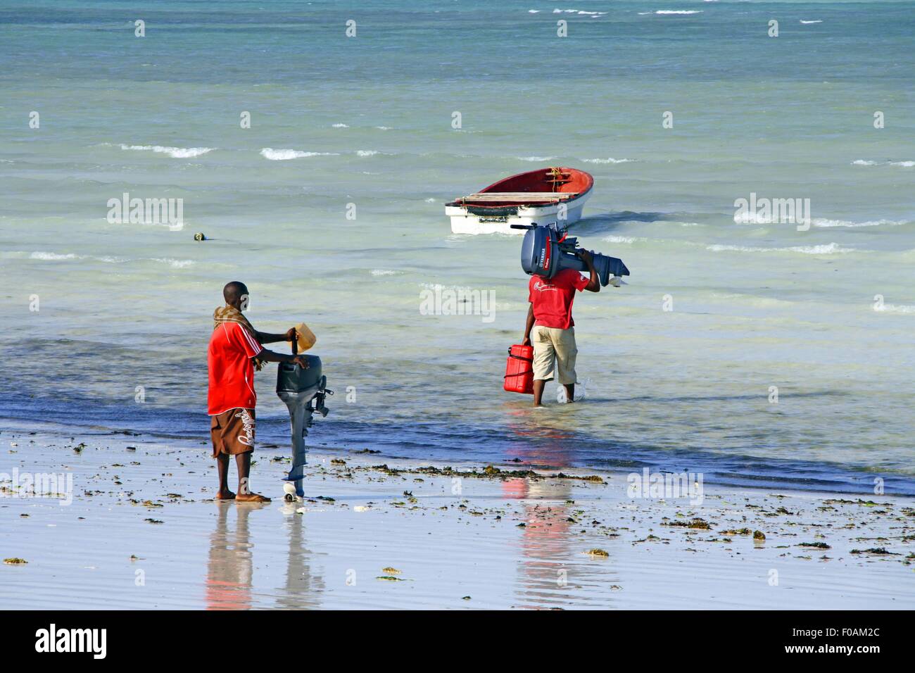 Man carrying boat motor in sea at Zanzibar, Tanzania, East Africa Stock ...