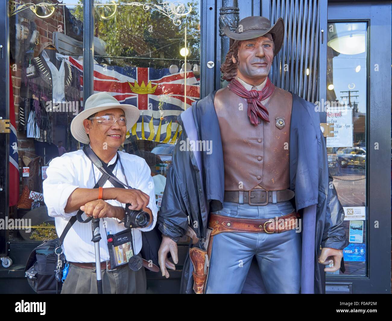 Tourist standing by the cowboy figure in Gastown, Vancouver, British ...