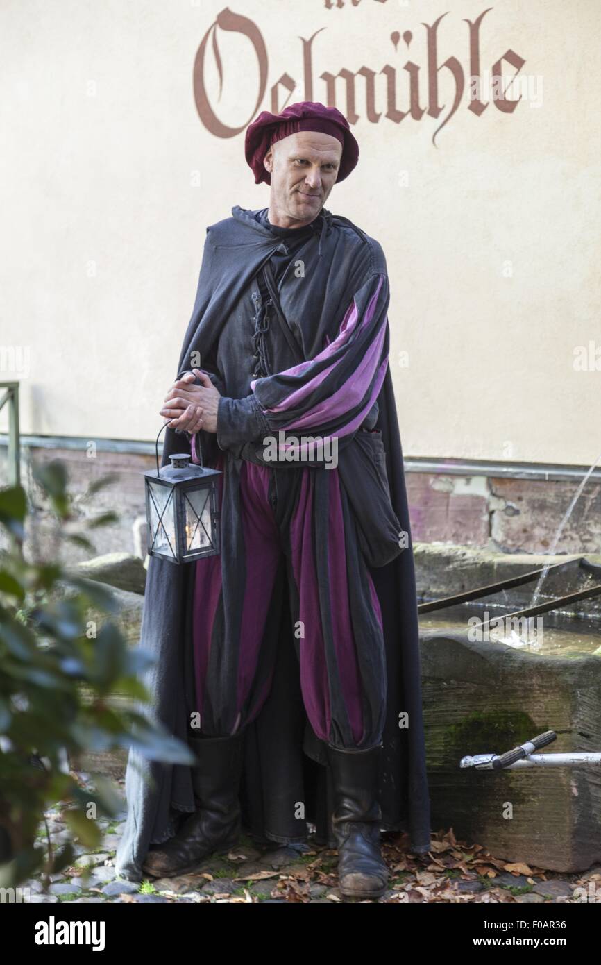 Medieval city leader standing against wall written with Oelmuhle in ...