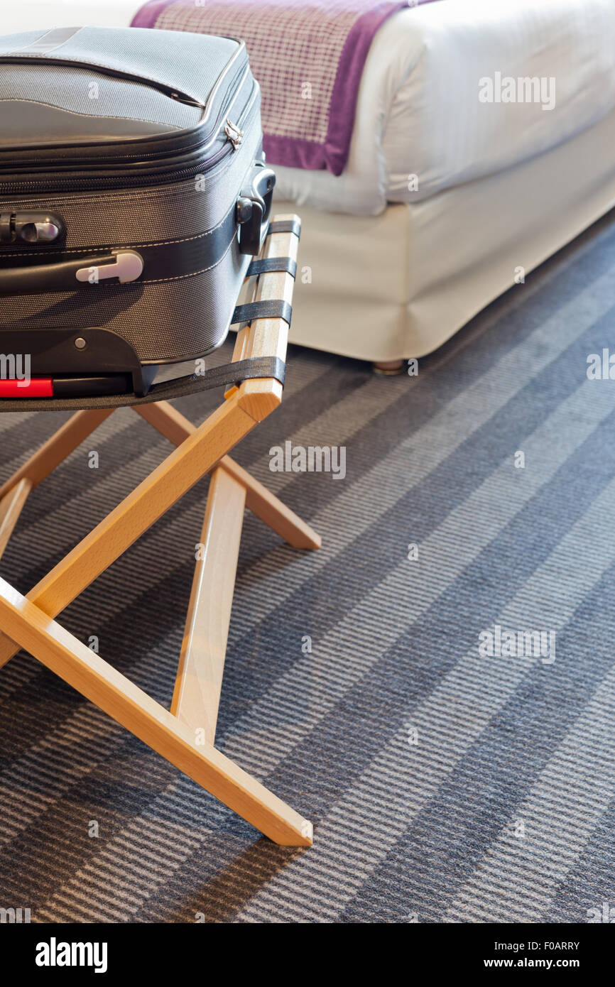 Hotel room with a suitcase on the luggage place and the bed Stock Photo ...