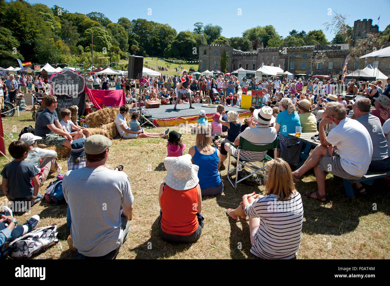 Crowds of families watch an acrobat show in the summer sunshine at the ...