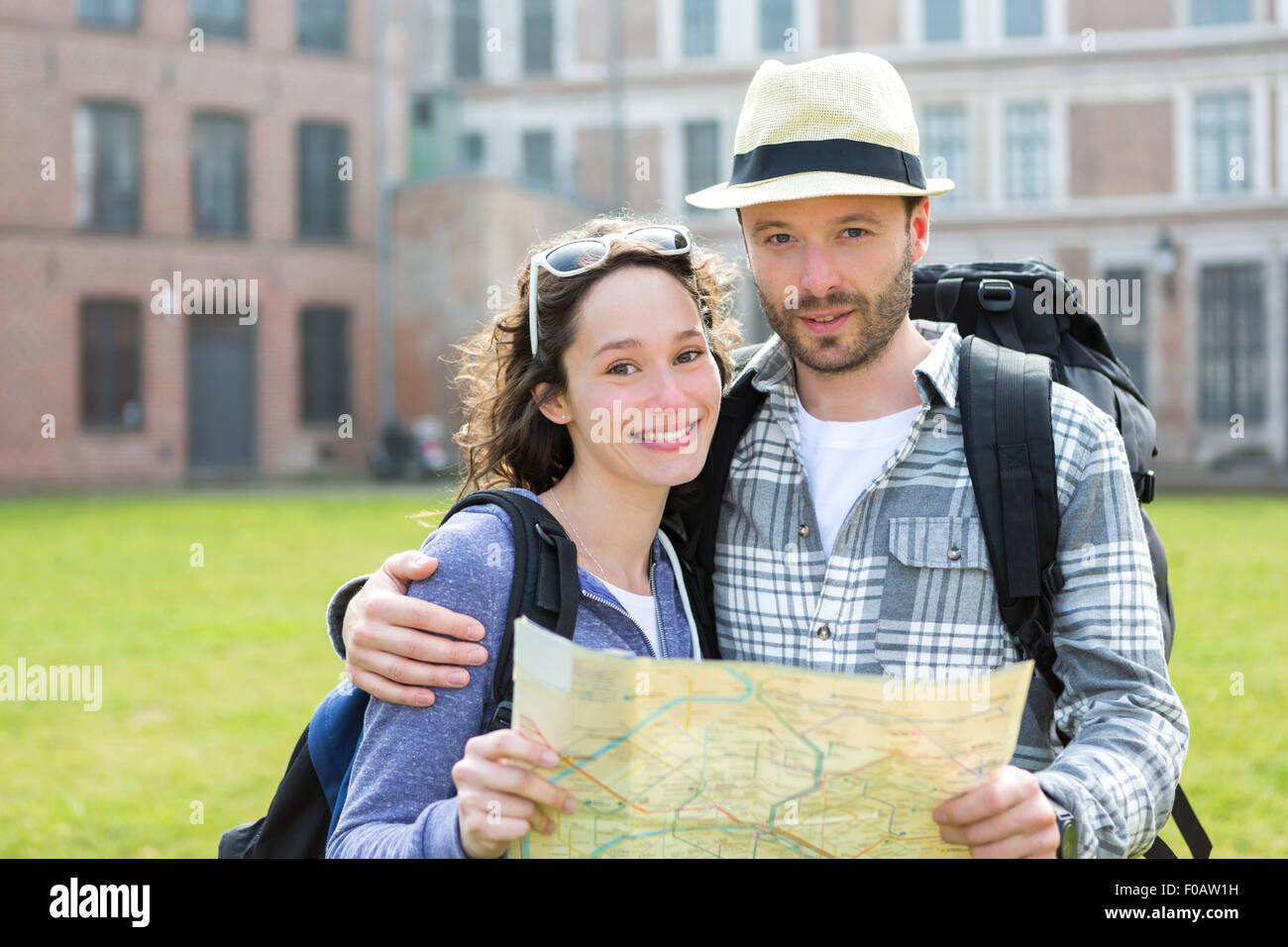 View of a Couple of young attractive tourists watching map Stock Photo ...