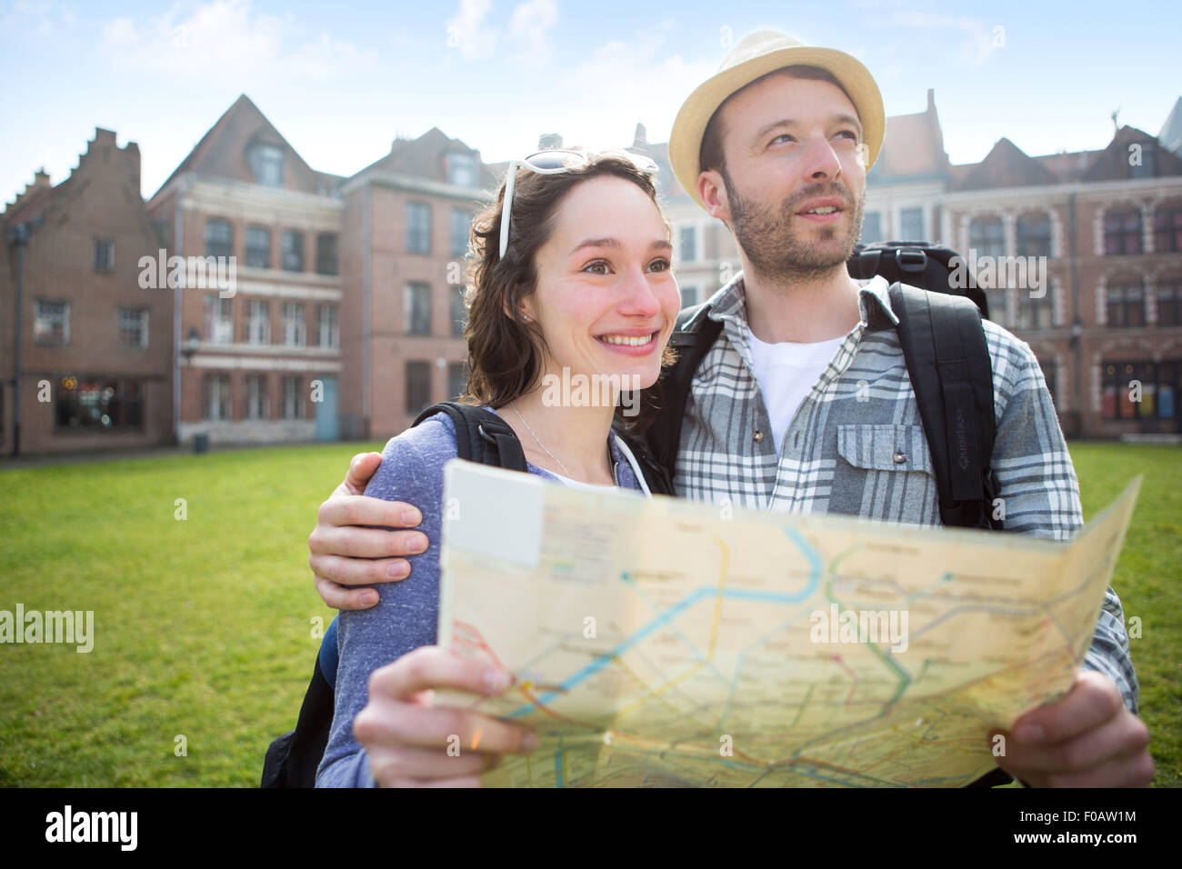 View of a Couple of young attractive tourists watching map Stock Photo ...