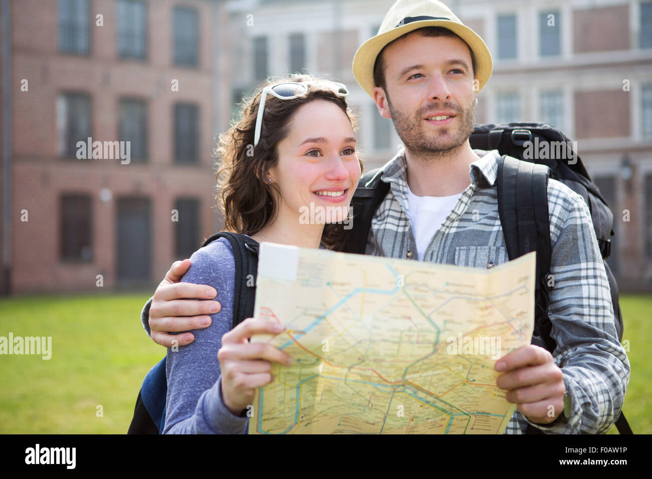View of a Couple of young attractive tourists watching map Stock Photo ...