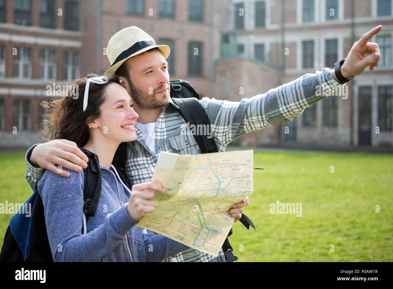 View of a Couple of young attractive tourists watching map Stock Photo ...