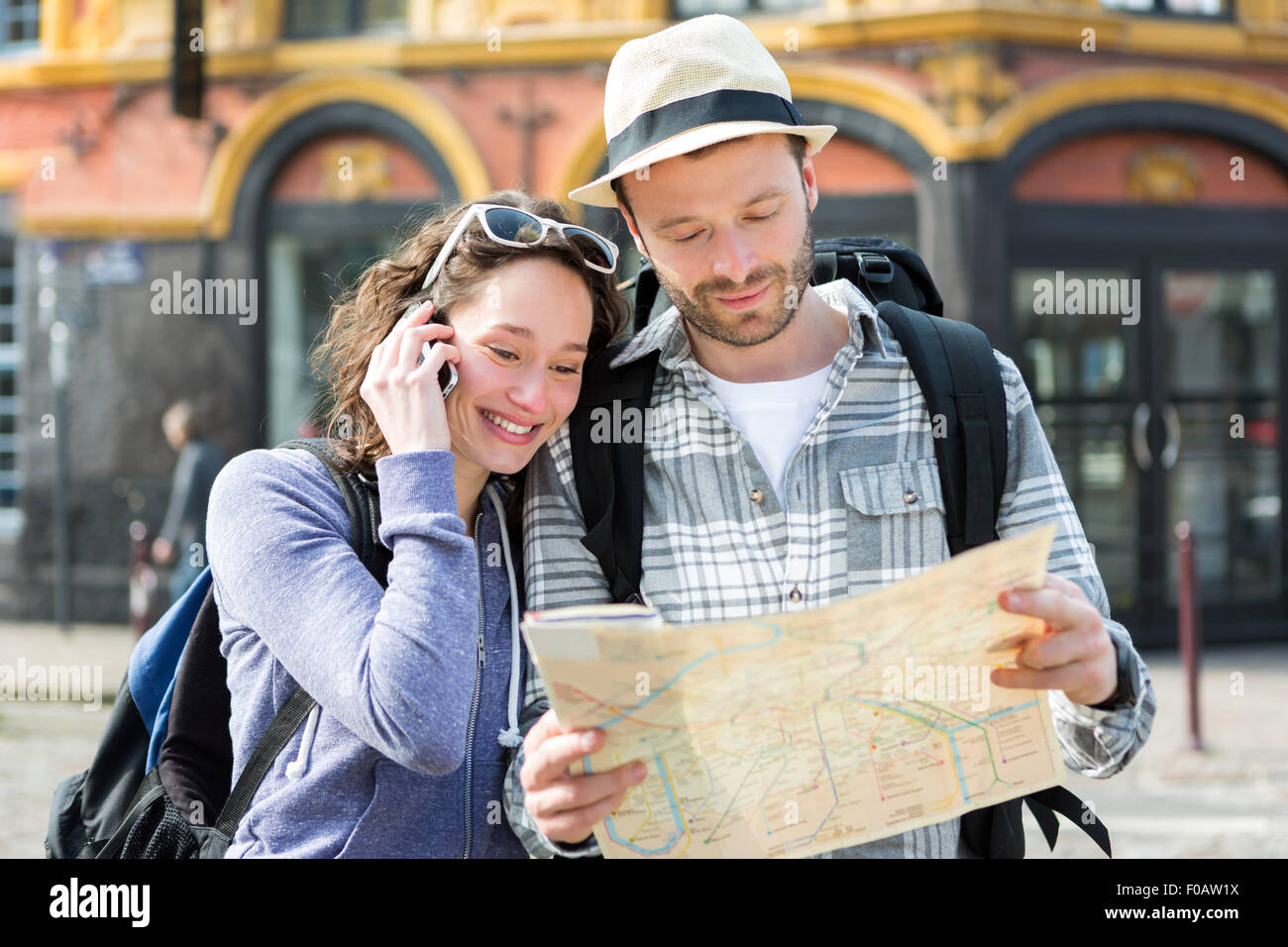 View of a Couple of young attractive tourists watching map Stock Photo ...