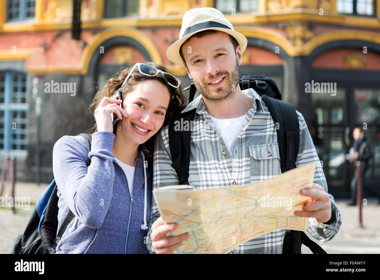 View of a Couple of young attractive tourists watching map Stock Photo ...