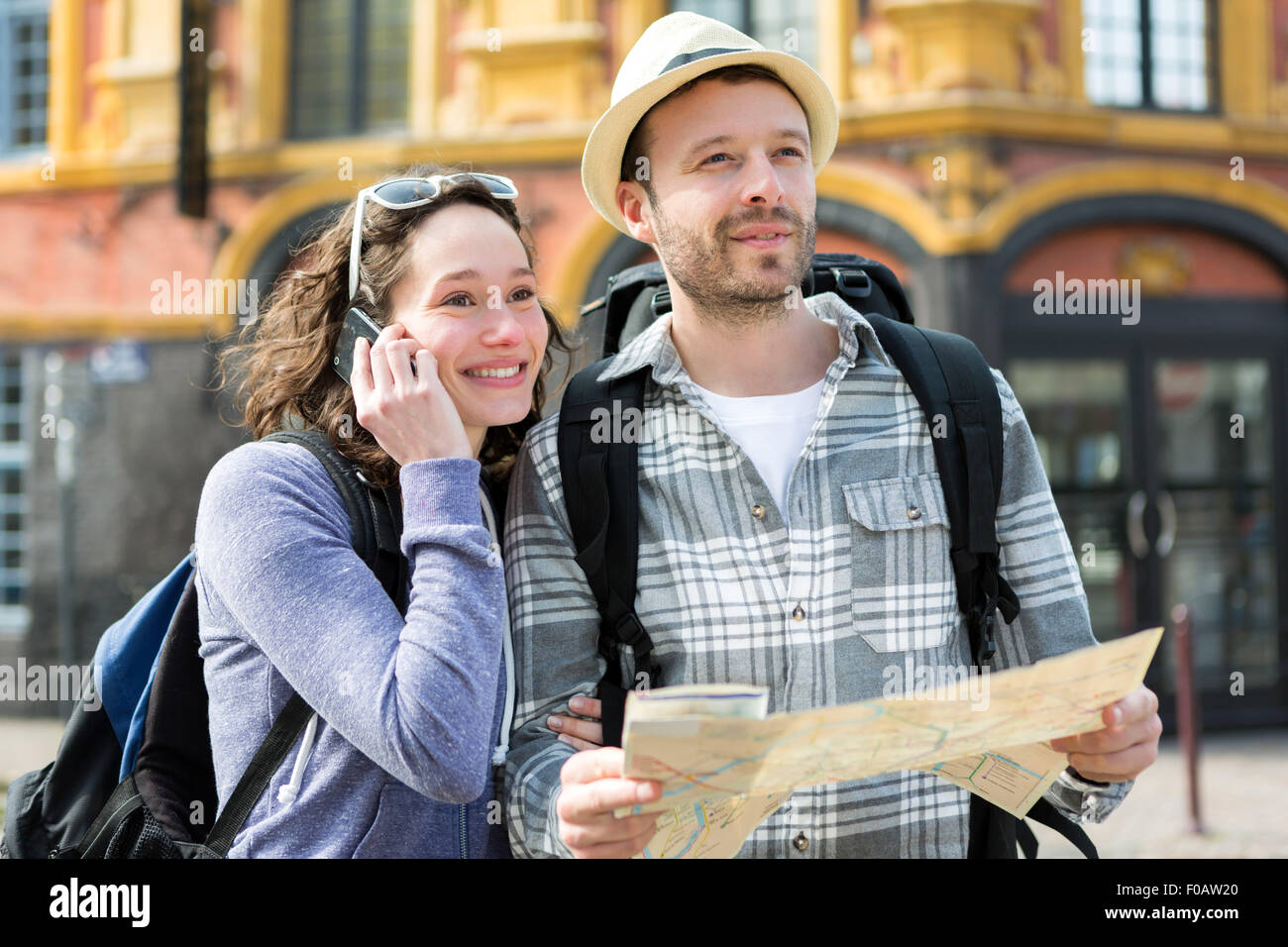 View of a Couple of young attractive tourists watching map Stock Photo ...