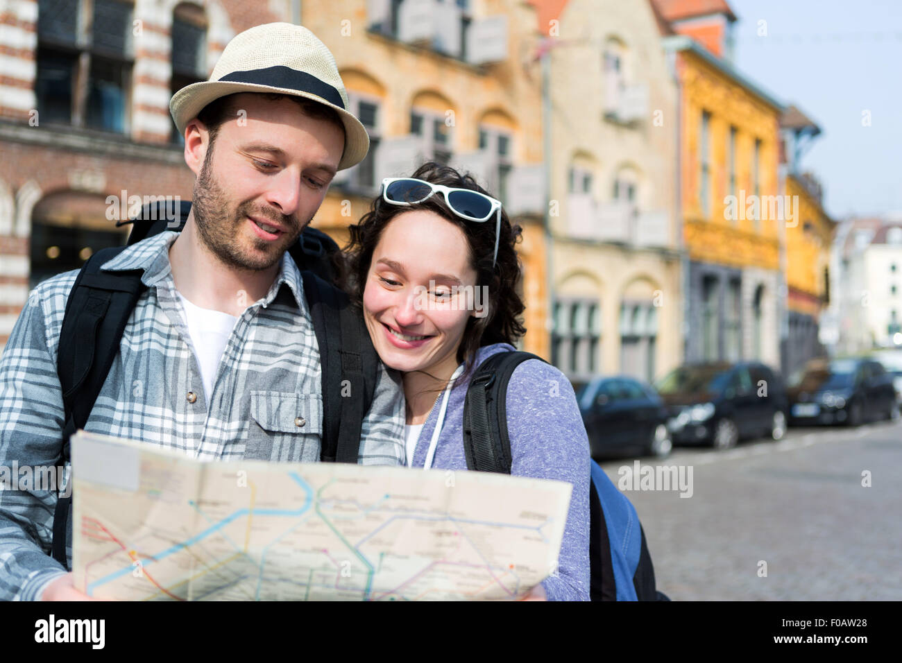 View of a Couple of young attractive tourists watching map Stock Photo ...