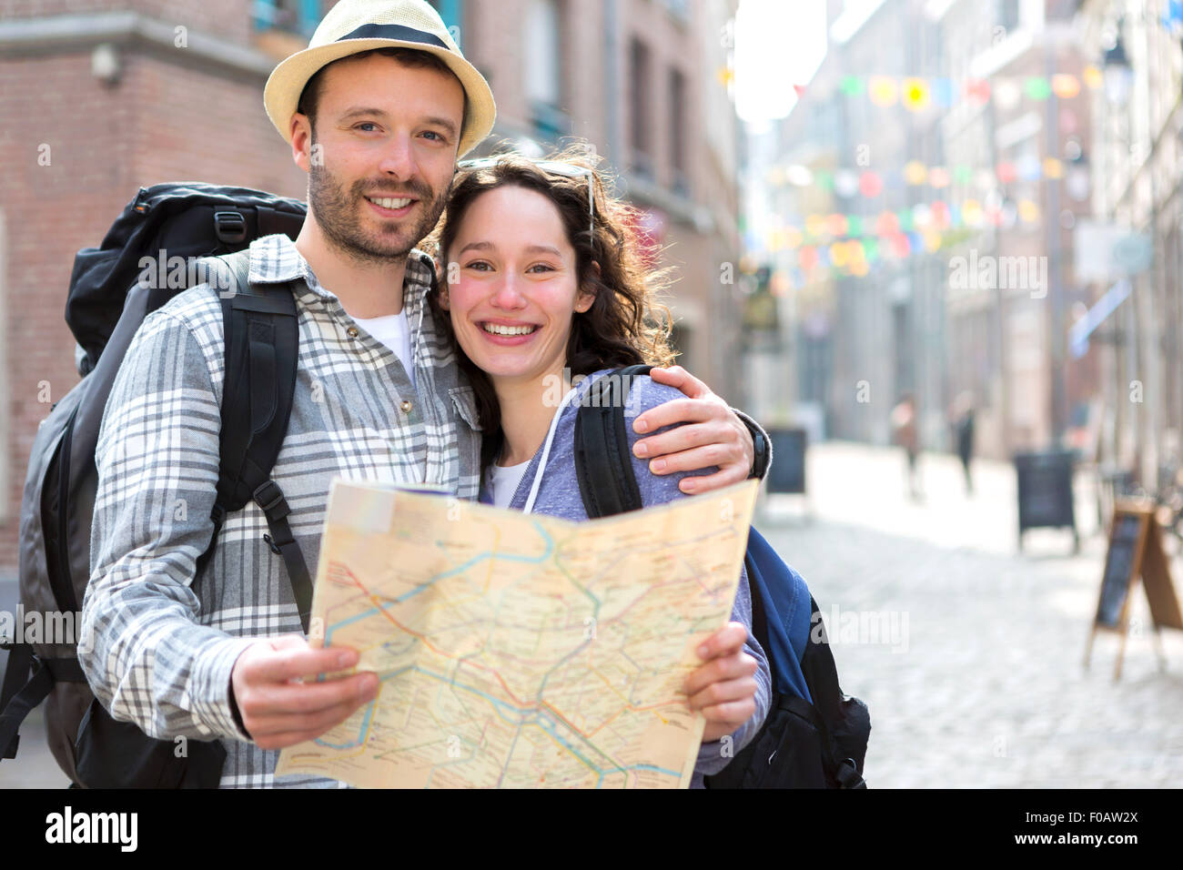 View of a Couple of young attractive tourists watching map Stock Photo ...