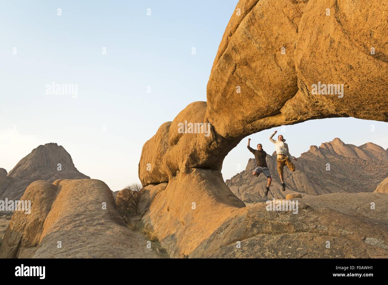 Tourists under the 'Rock Arch' bridge in the Spitzkoppe region with a ...
