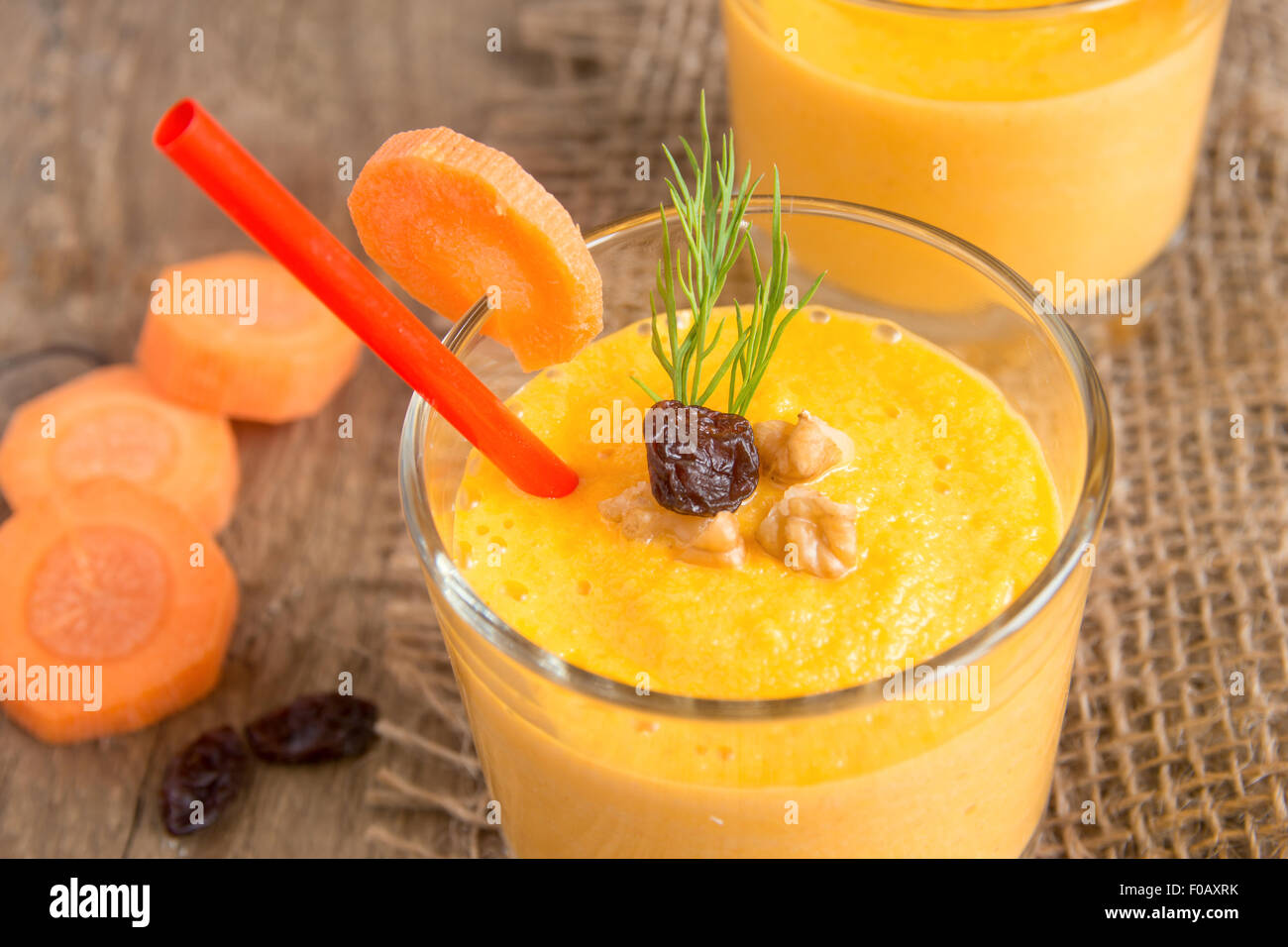 Carrot smoothie with nuts and raisin on wooden background, horizontal ...
