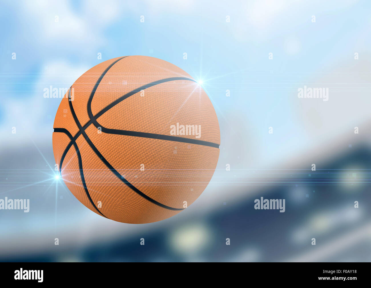 A regular basketball flying through the air on a stadium background ...