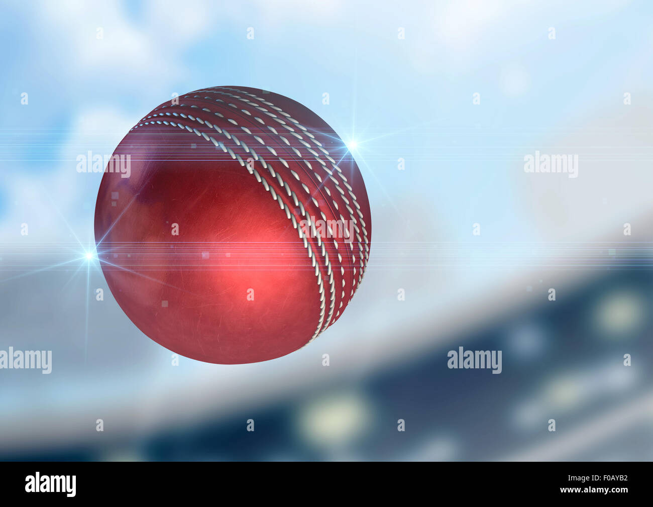 A regular red cricket ball flying through the air on a stadium ...