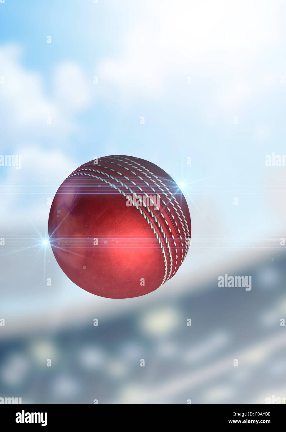 A regular red cricket ball flying through the air on a stadium ...