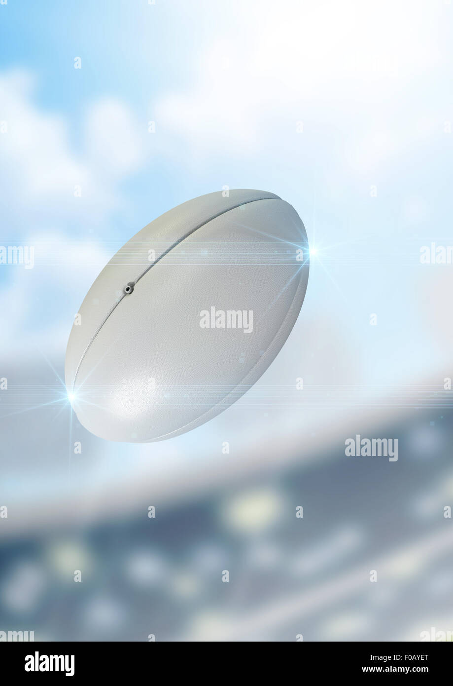 A regular rugby ball flying through the air on a stadium background ...
