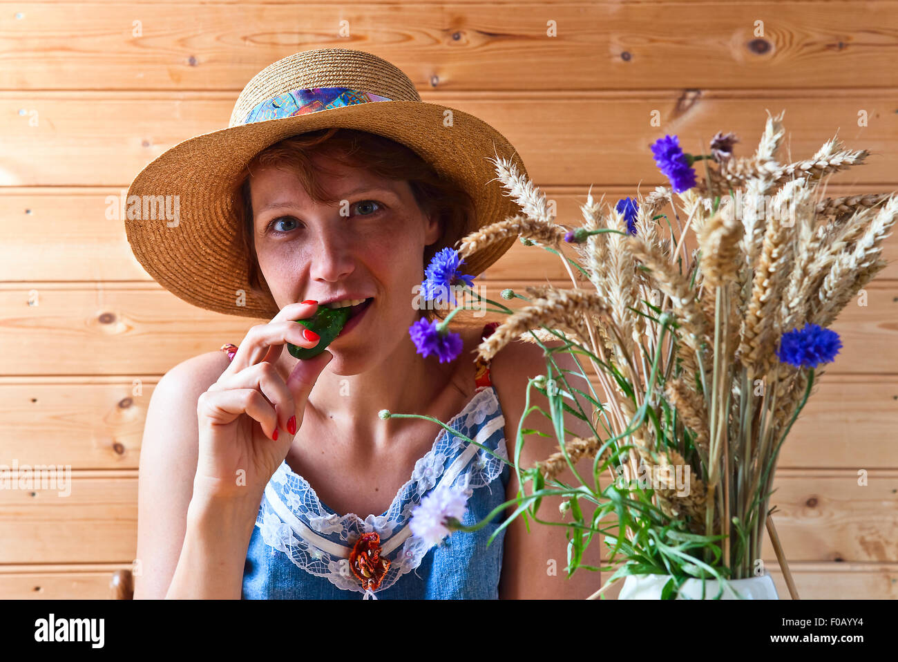 middle age woman in straw hat with cucumber Stock Photo - Alamy