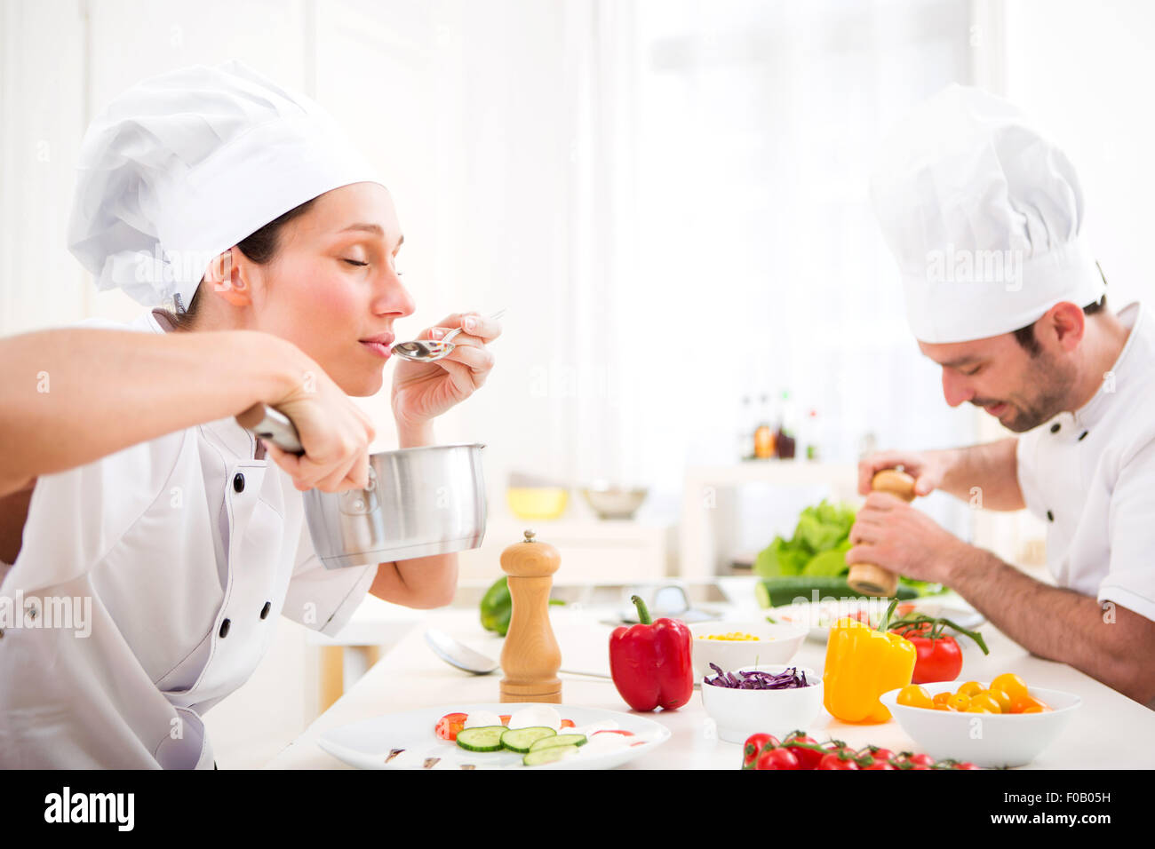 View of a Young attractive professional chef tasting sauce Stock Photo ...