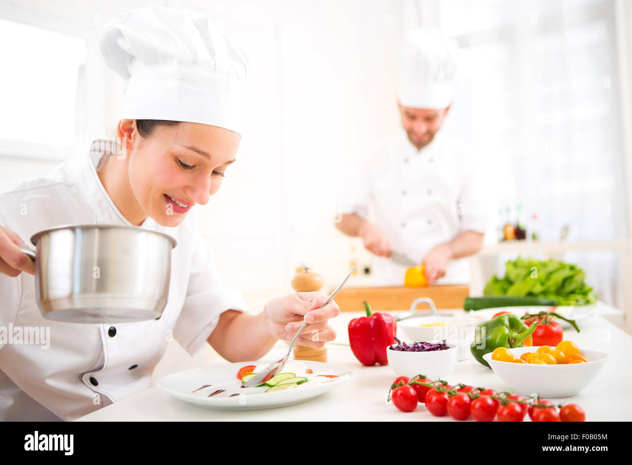 View of a Young attractive professional chef cooking in his kitchen ...
