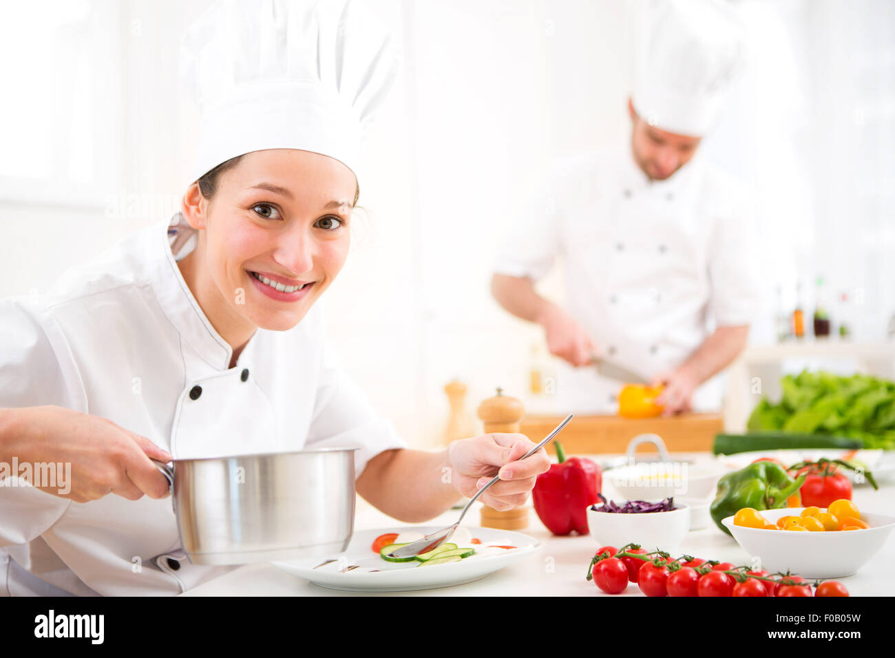 View of a Young attractive professional chef cooking in his kitchen ...