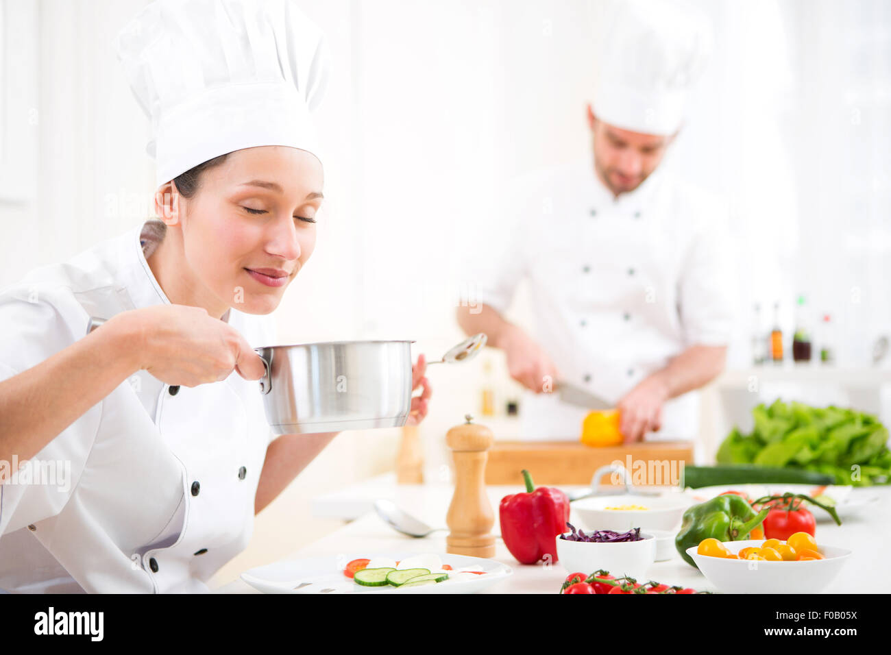 View of a Young attractive professional chef tasting sauce Stock Photo ...