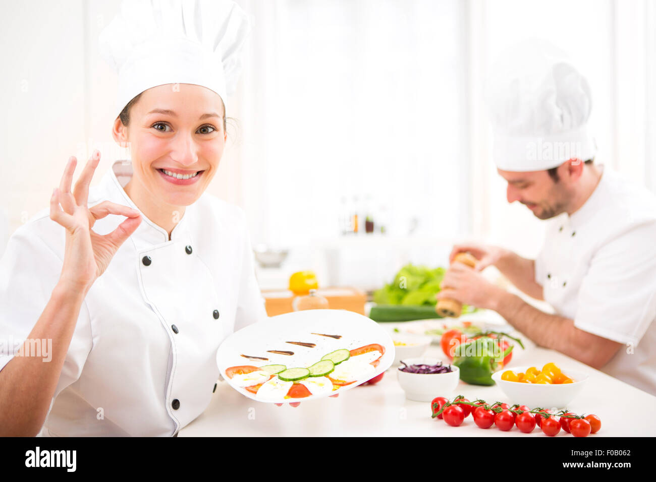 View of a Young attractive professional chef cooking in his kitchen ...