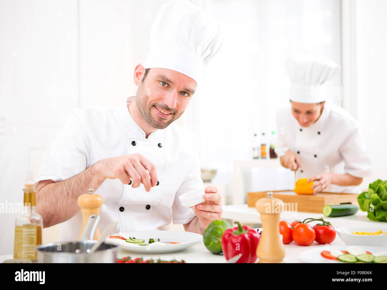 View of a Young attractive professional chef cooking in his kitchen ...